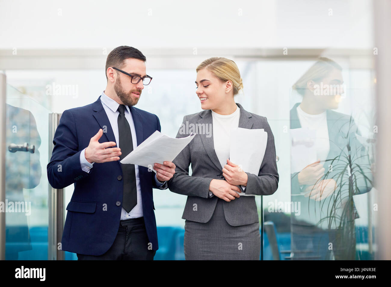 Two employees discussing business documents Stock Photo - Alamy