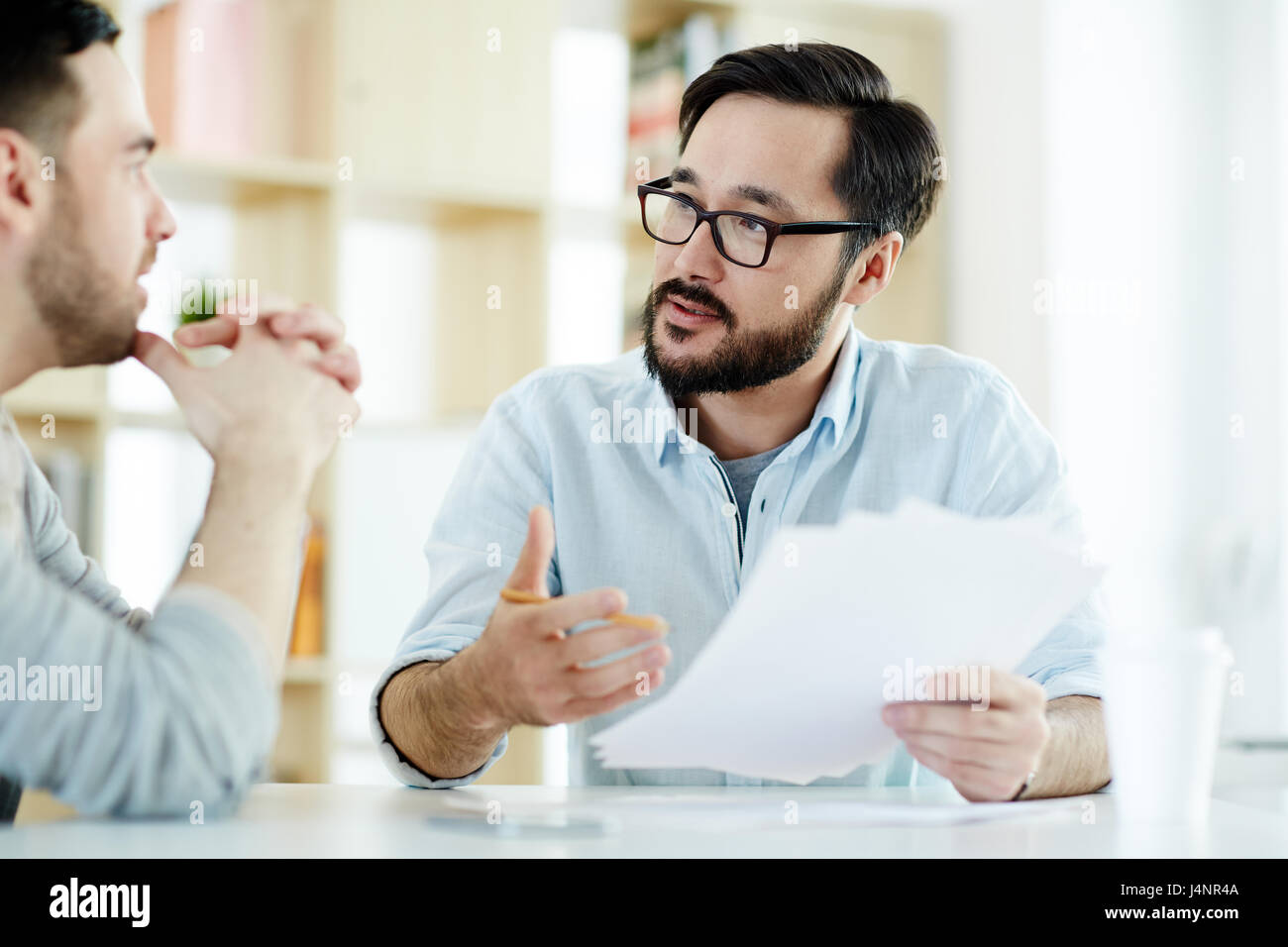 Two managers discussing financial documents at meeting Stock Photo - Alamy