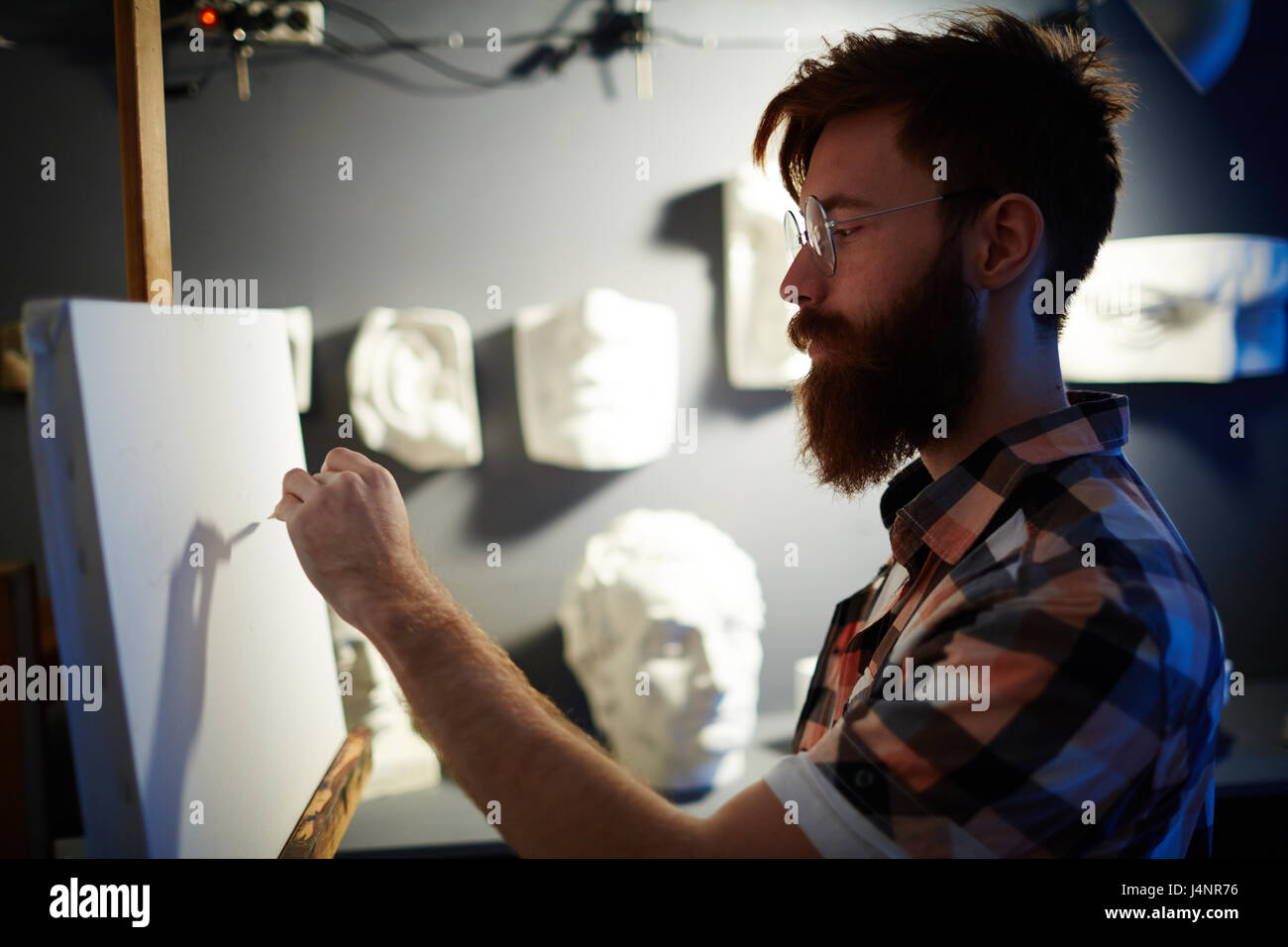 Portrait of inspired young red-haired man drawing first lines of ...
