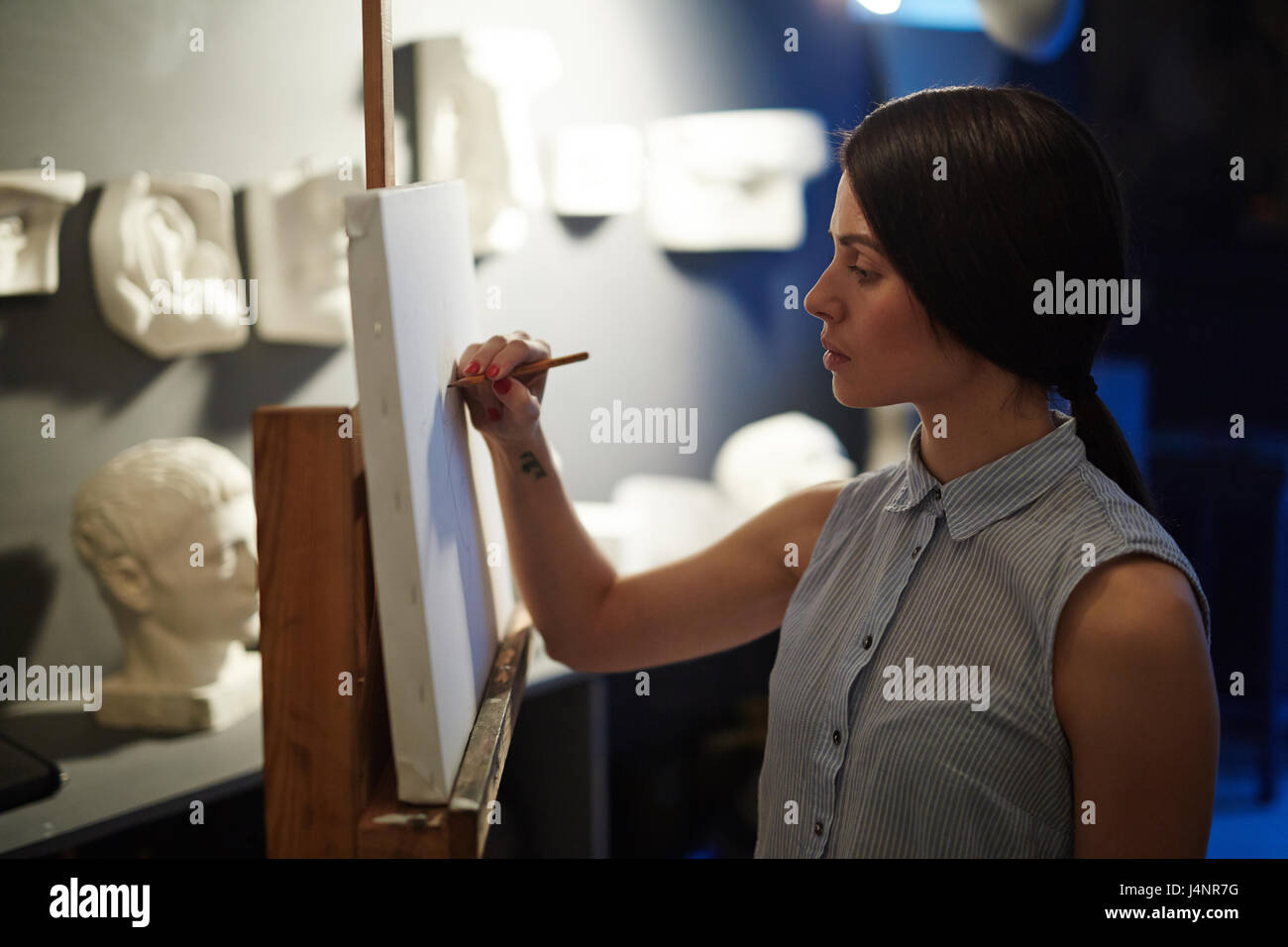 Portrait of inspired young woman drawing first lines of picture on ...