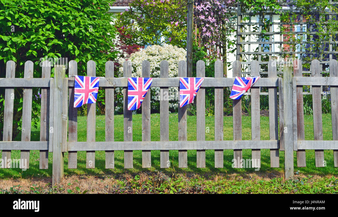 Four Little Union Jack Flags On The Fence Of An English Garden Stock ...