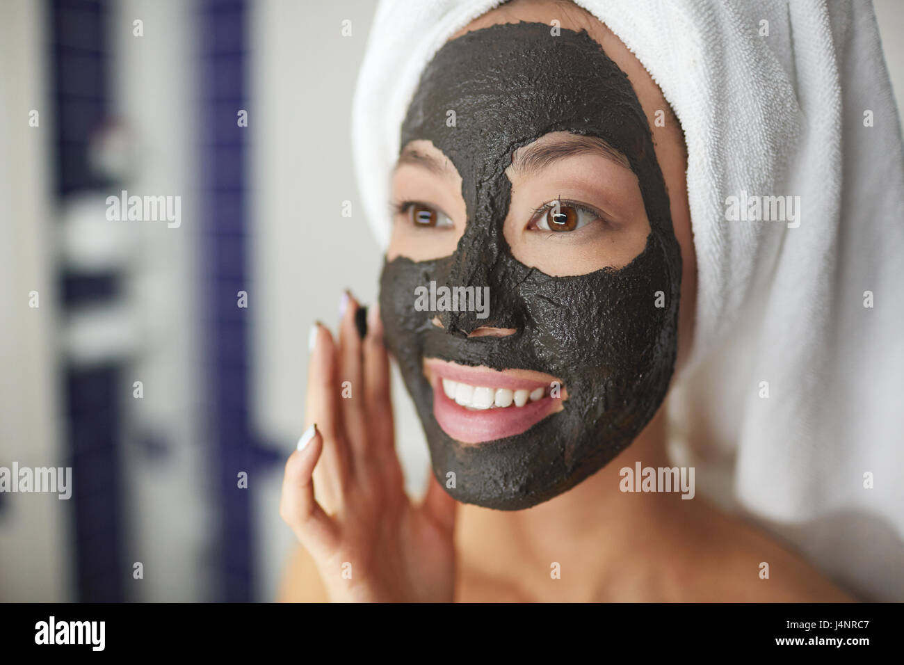Closeup portrait of beautiful Asian woman applying face mask Stock ...