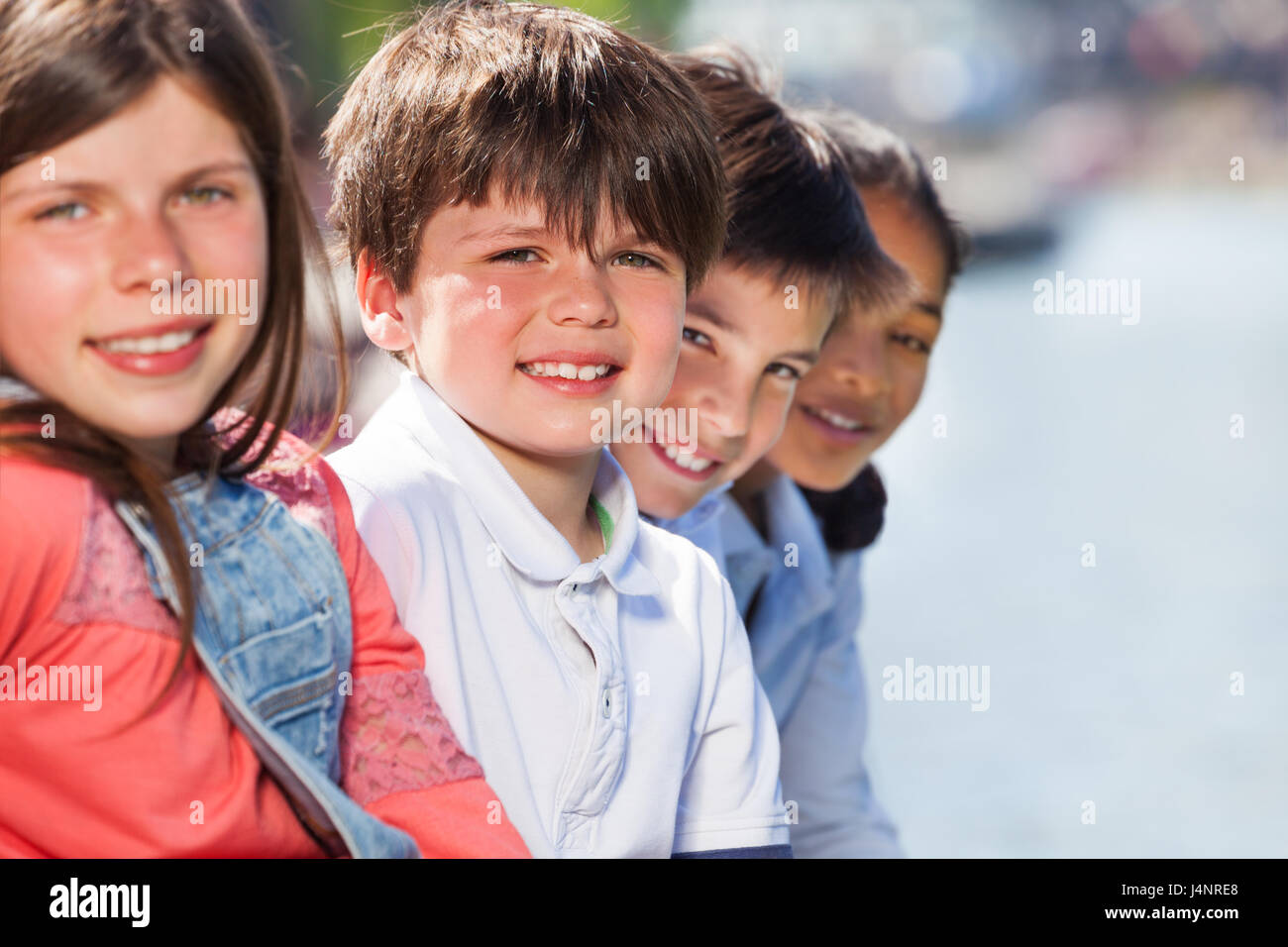 Close-up picture of multinational group of smiling kids sitting ...