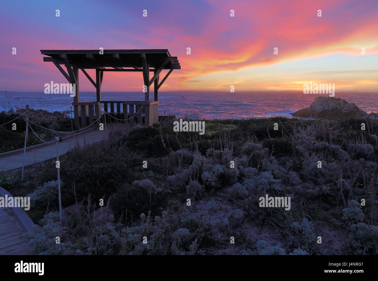 Dramatic clouds at sunset behind a public walkway and gazebo at ...