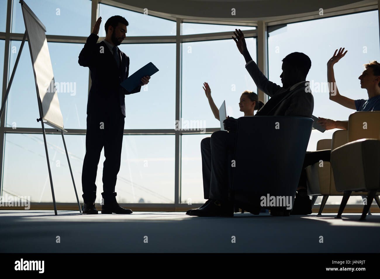 Group of analysts raising hands during presentation Stock Photo - Alamy