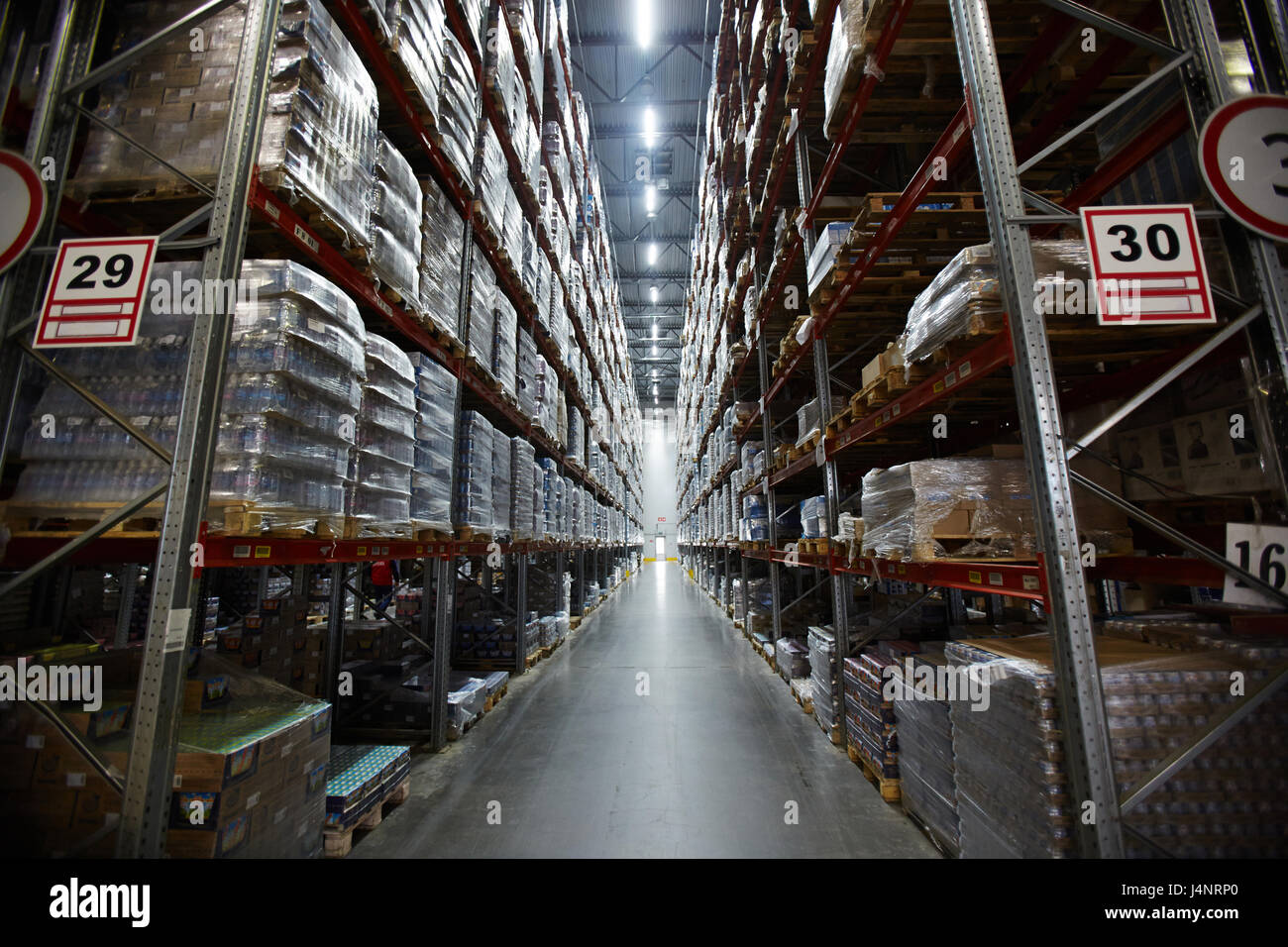 Aisle in warehouse between shelves with goods Stock Photo - Alamy