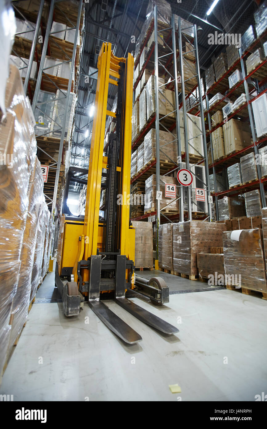 Forklift in aisle of large-scale warehouse Stock Photo - Alamy