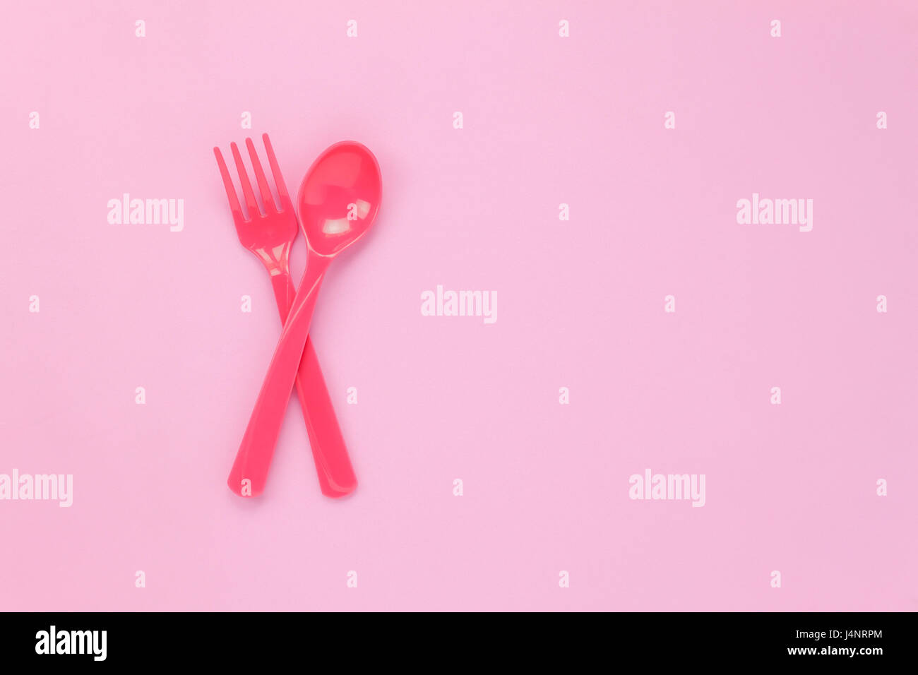 Top view colorful plastic spoon on pink table background with copy ...