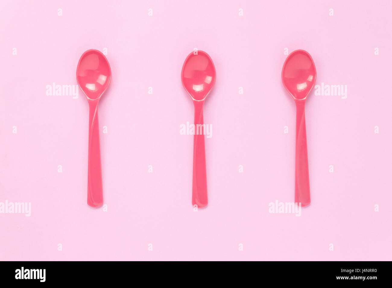 Top view colorful plastic spoon on pink table background with copy ...