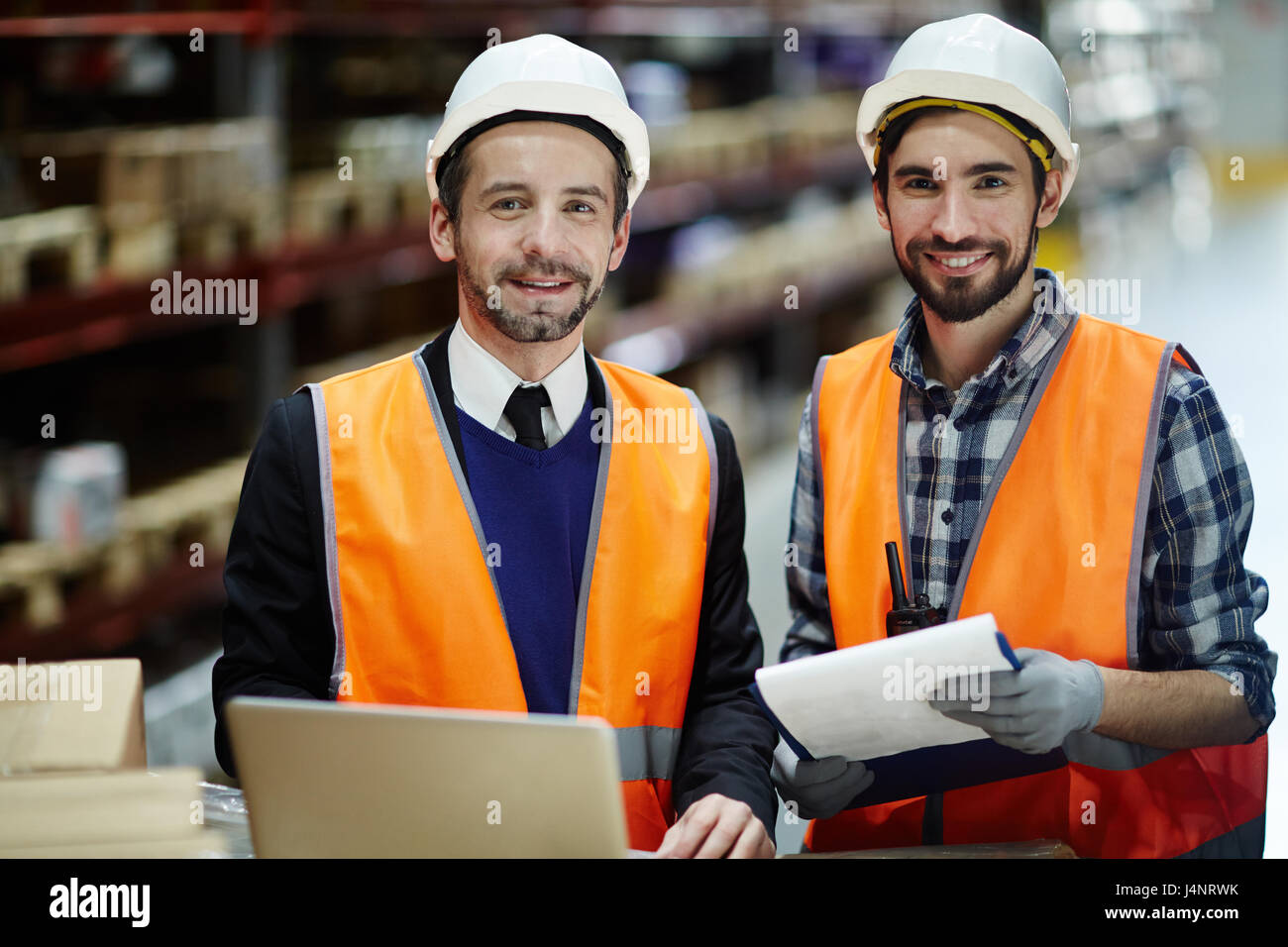 Happy young workers of storage house looking at camera Stock Photo - Alamy