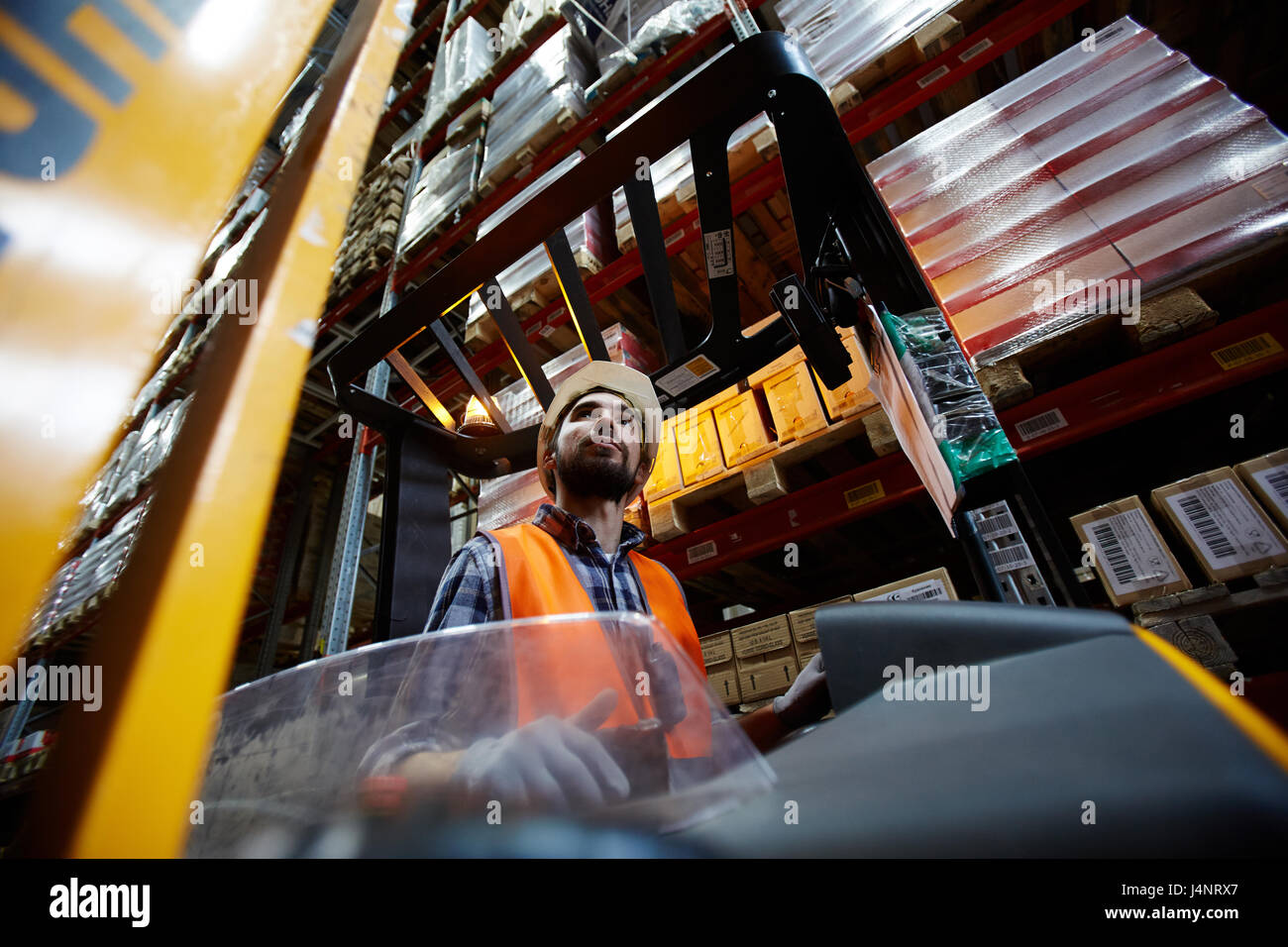 Warehouse worke loading heavy packages with goods Stock Photo - Alamy