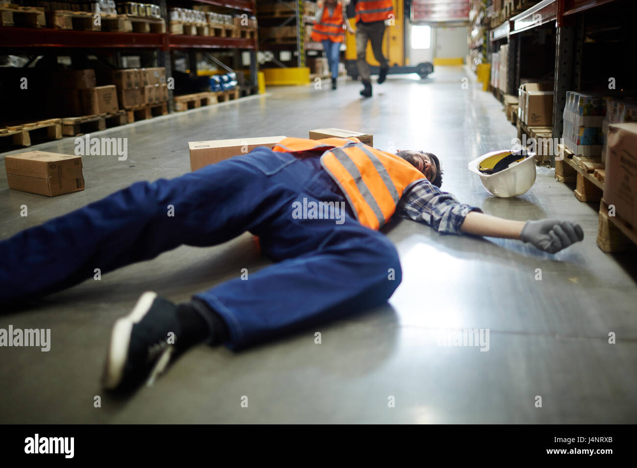 Fallen worker lying on the floor in aisle between storage shelves Stock ...