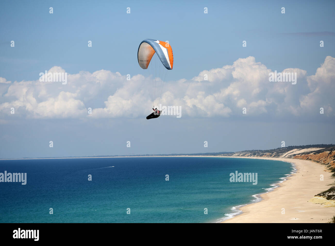 A paragliding pilot flying over the surf at Aberta Nova beach Stock ...