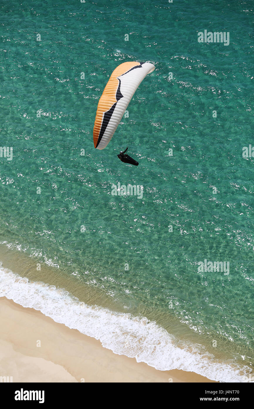 A paragliding pilot flying over the surf at Aberta Nova beach Stock ...