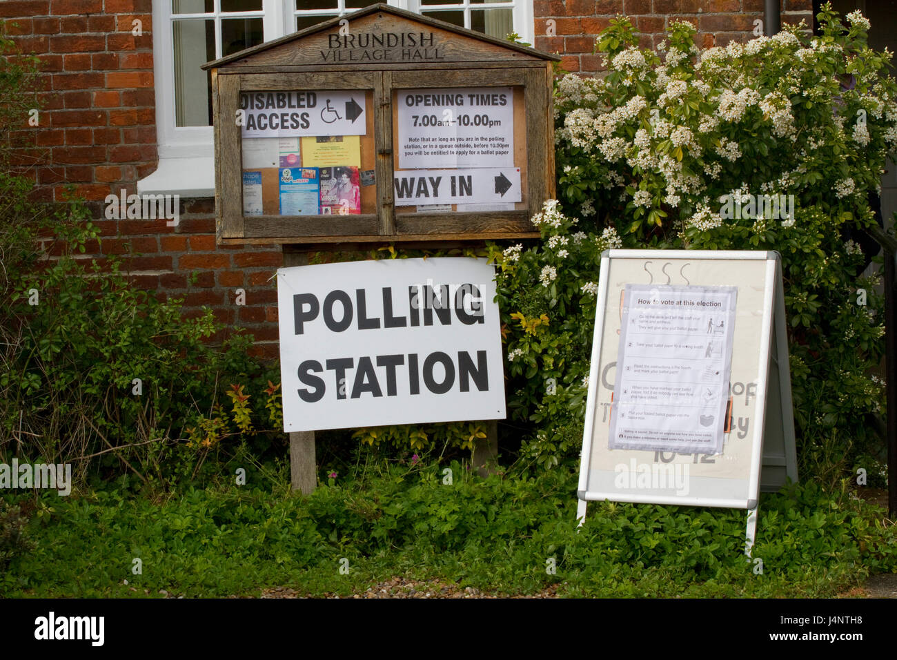 Polling station sign by a village noticeboard Stock Photo - Alamy