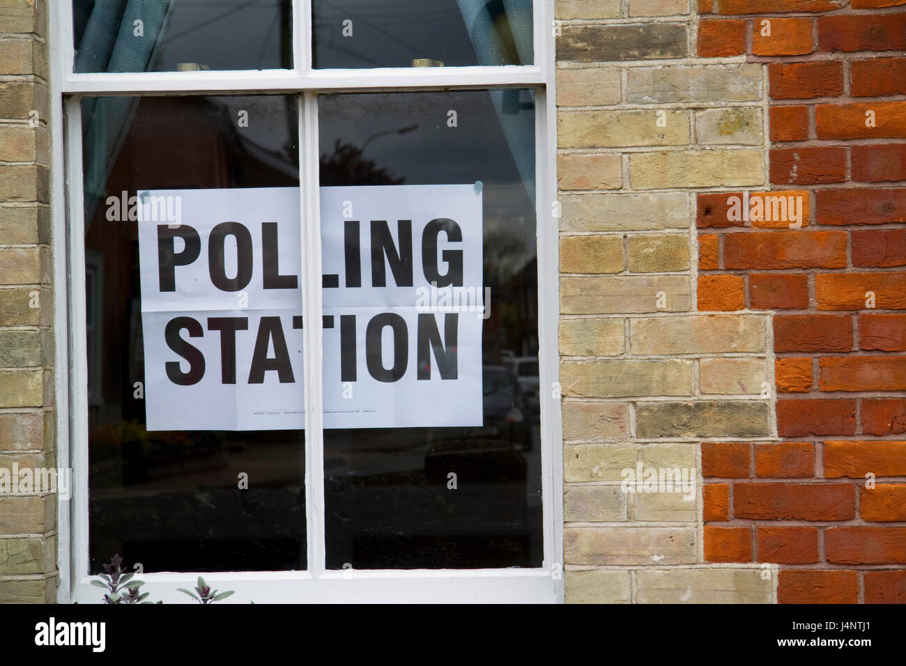 Polling station sign displayed in a window Stock Photo - Alamy