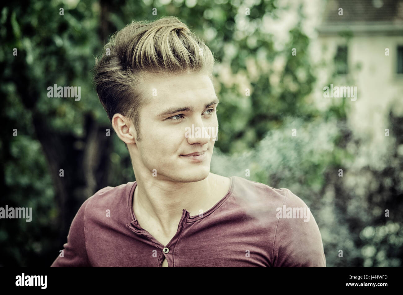 Attractive blue eyed, blond young man smoking Stock Photo - Alamy