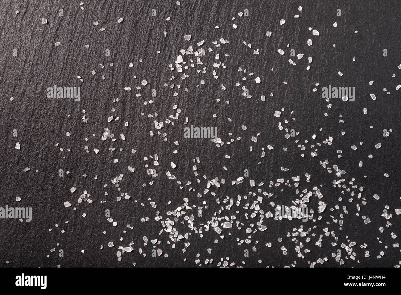flat lay of beautiful trendy sprinkled sea salt over black slate stone ...