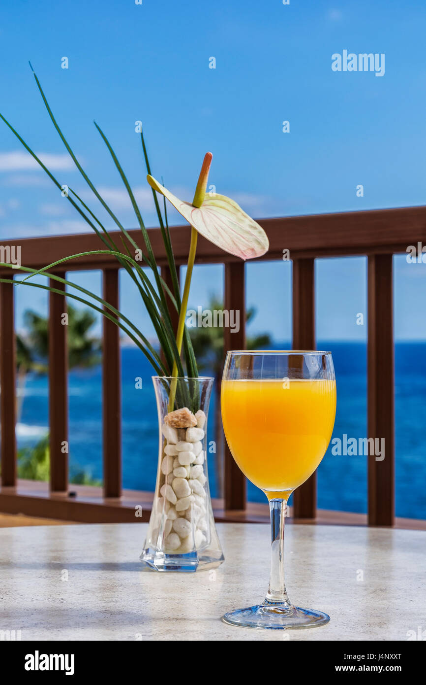A glass of orange juice stands on a table in the street Stock Photo - Alamy
