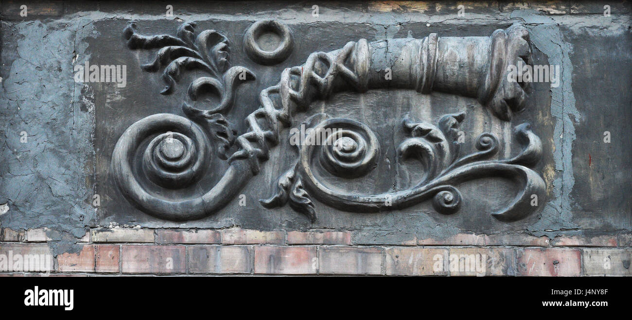 Embossed three-dimensional image on the wall of an old house above the ...