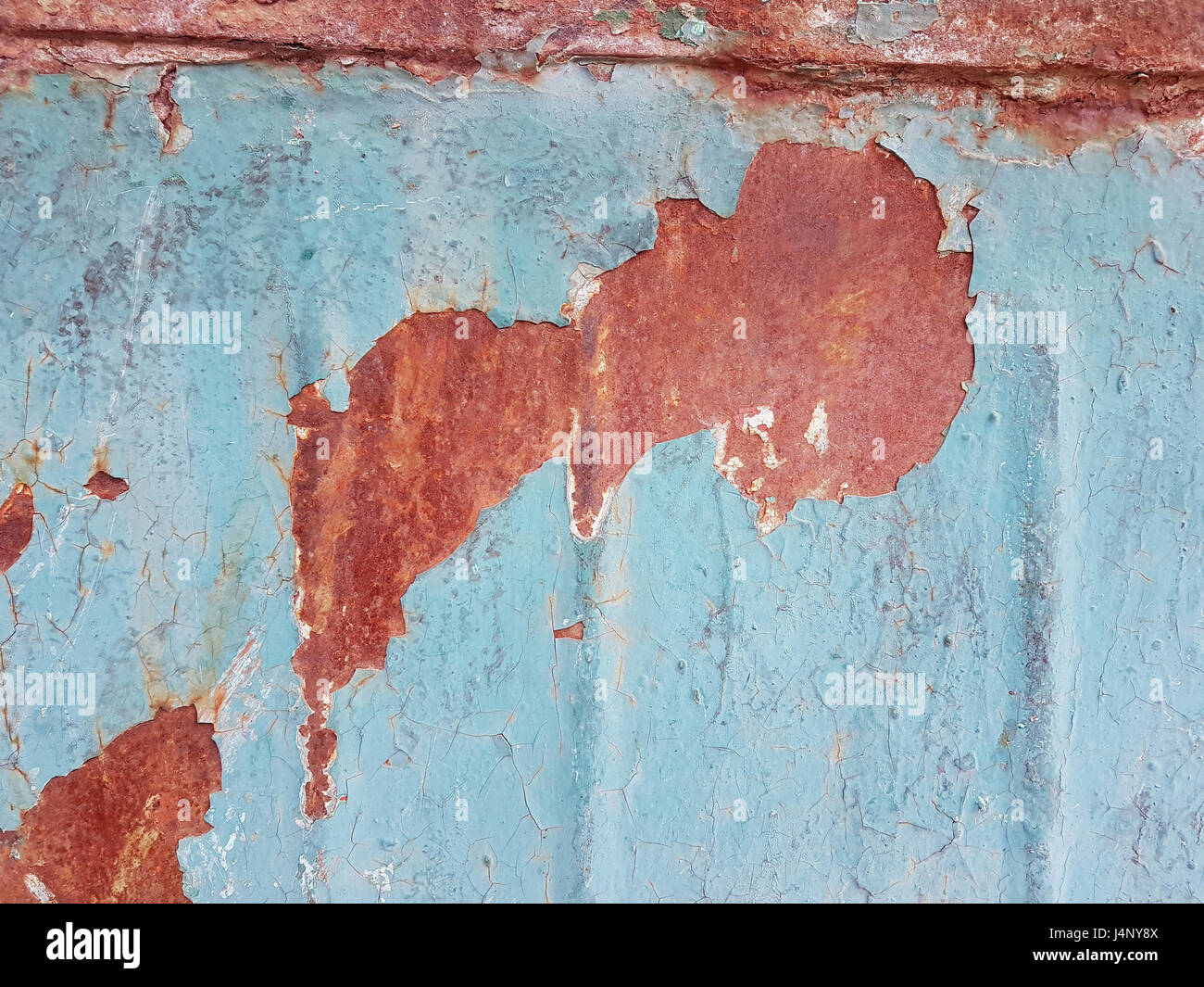 Piece of old rusty bent iron sheet painted in blue, with rust fragments ...