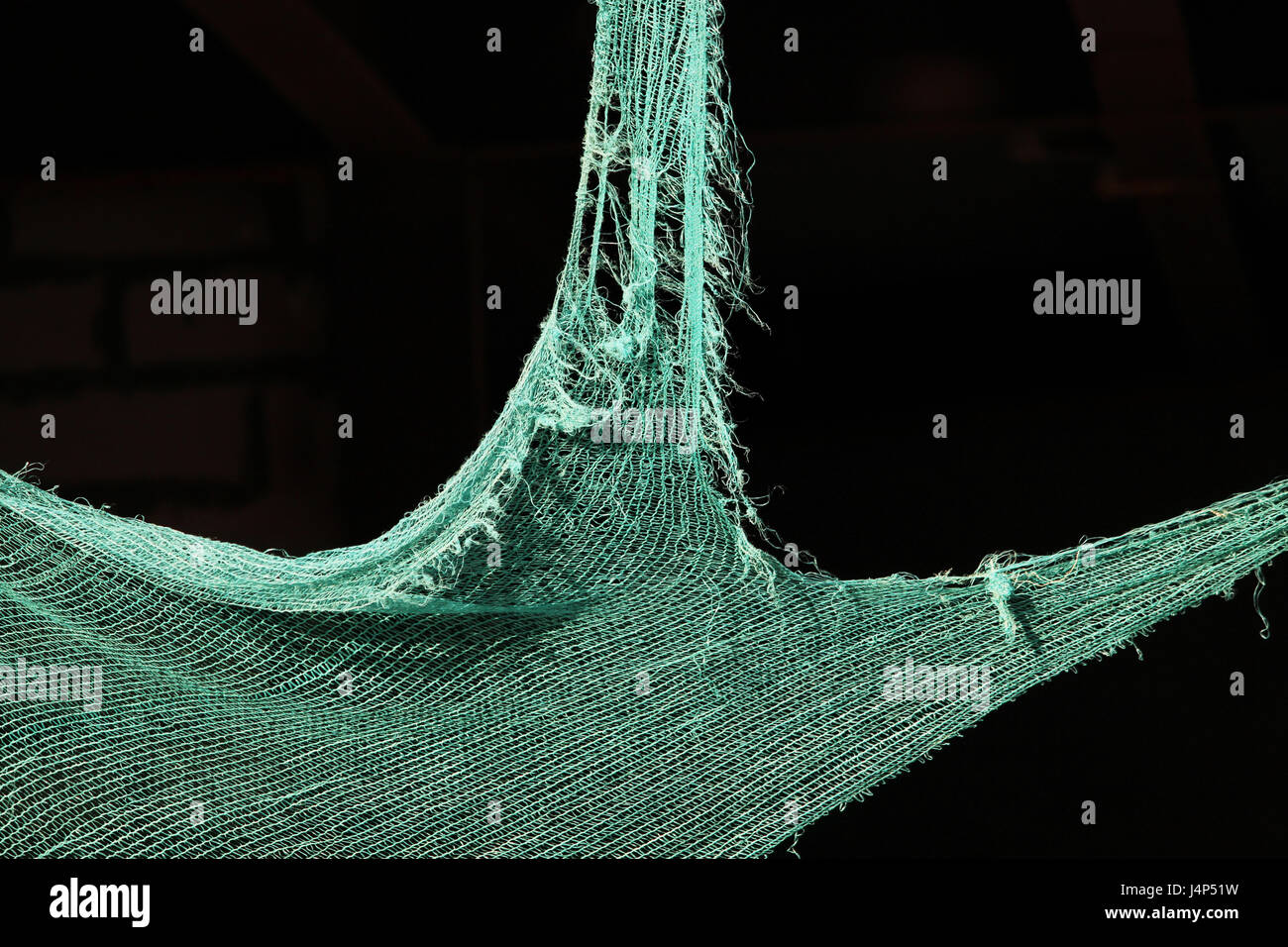 Torn green building mesh on an unguarded unfinished abandoned building ...