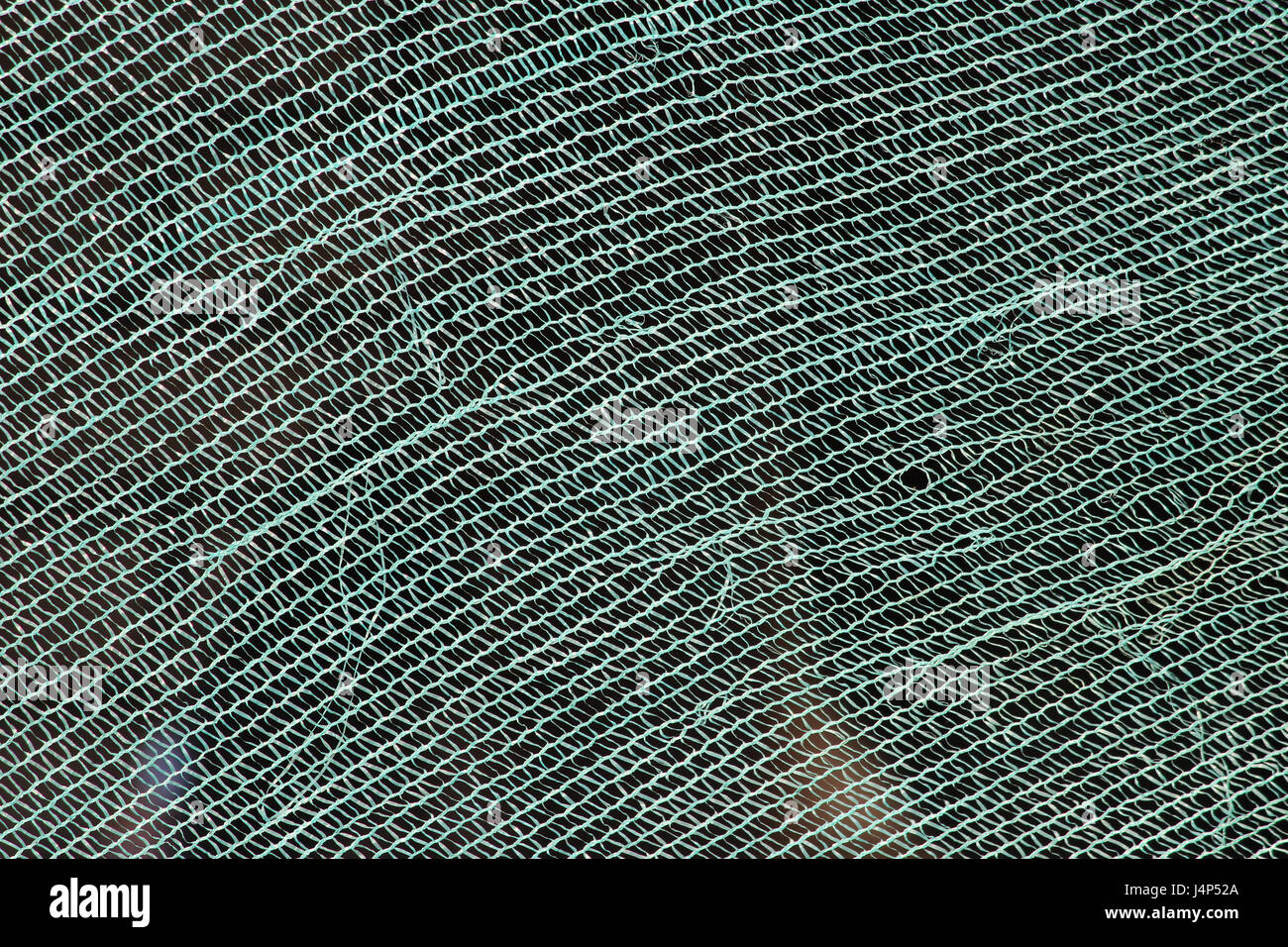 Under construction building wrapped with green net for debris safety ...