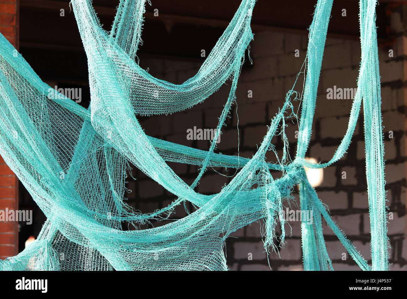 Torn green building mesh on an unguarded unfinished abandoned building ...
