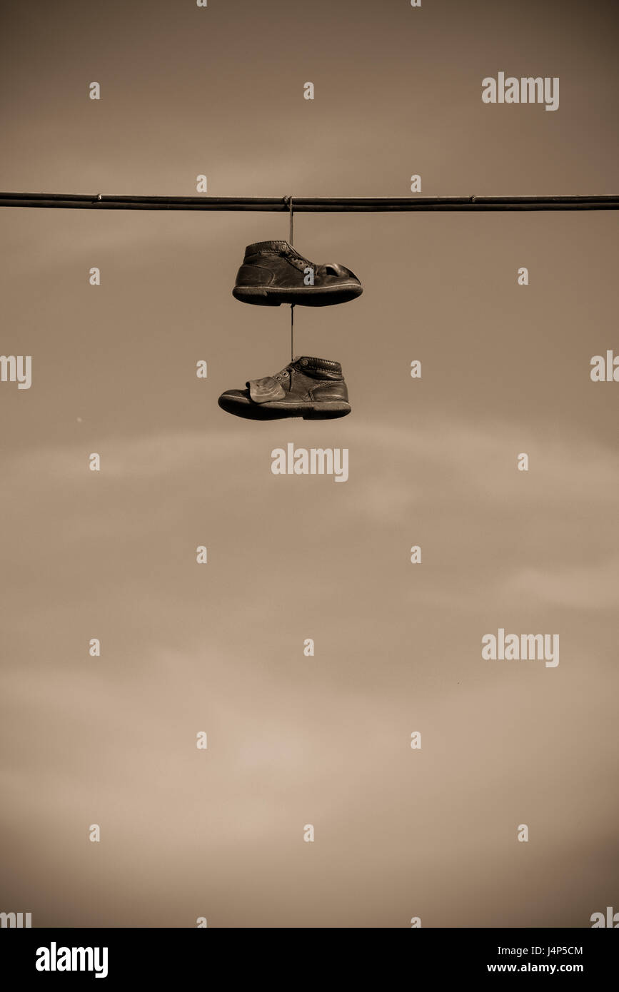 Old shoes hang on wire hi-res stock photography and images - Alamy