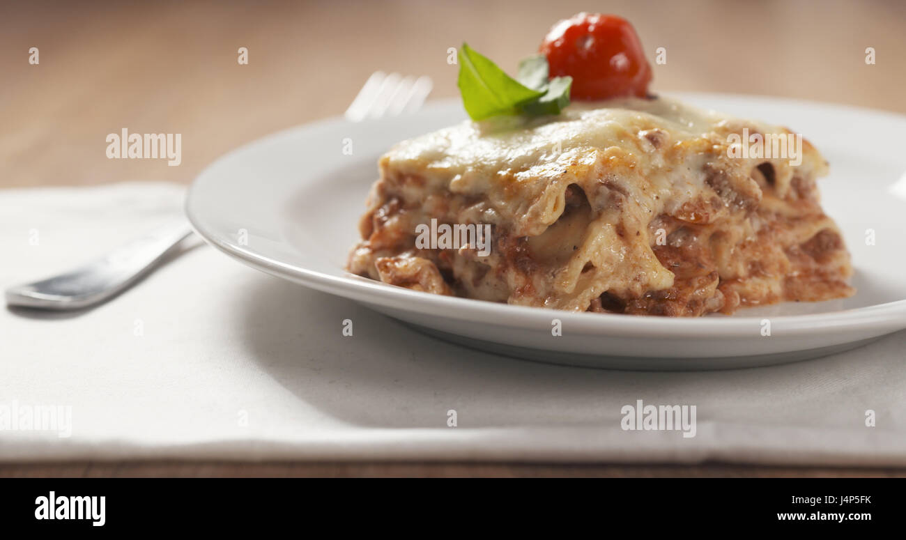 homemade lasagna portion on white plate on wood table Stock Photo - Alamy