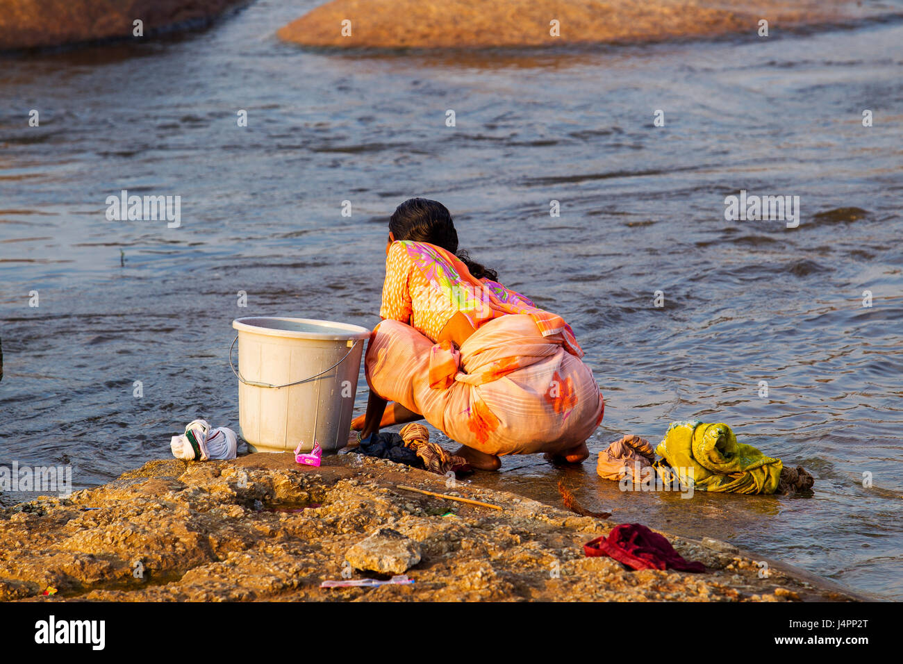 Indian woman washing clothes at Tungabhadra River, Hampi, Karnataka ...