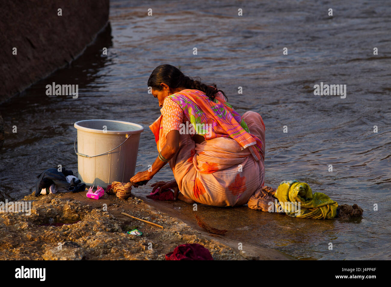 Indian woman washing clothes at Tungabhadra River, Hampi, Karnataka ...