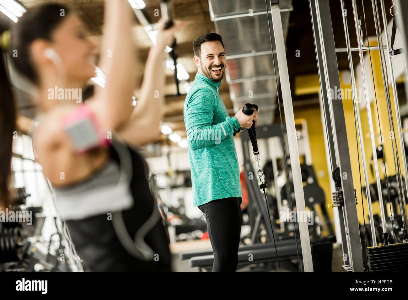 Active female weightlifting in sports club with her coach consulting ...