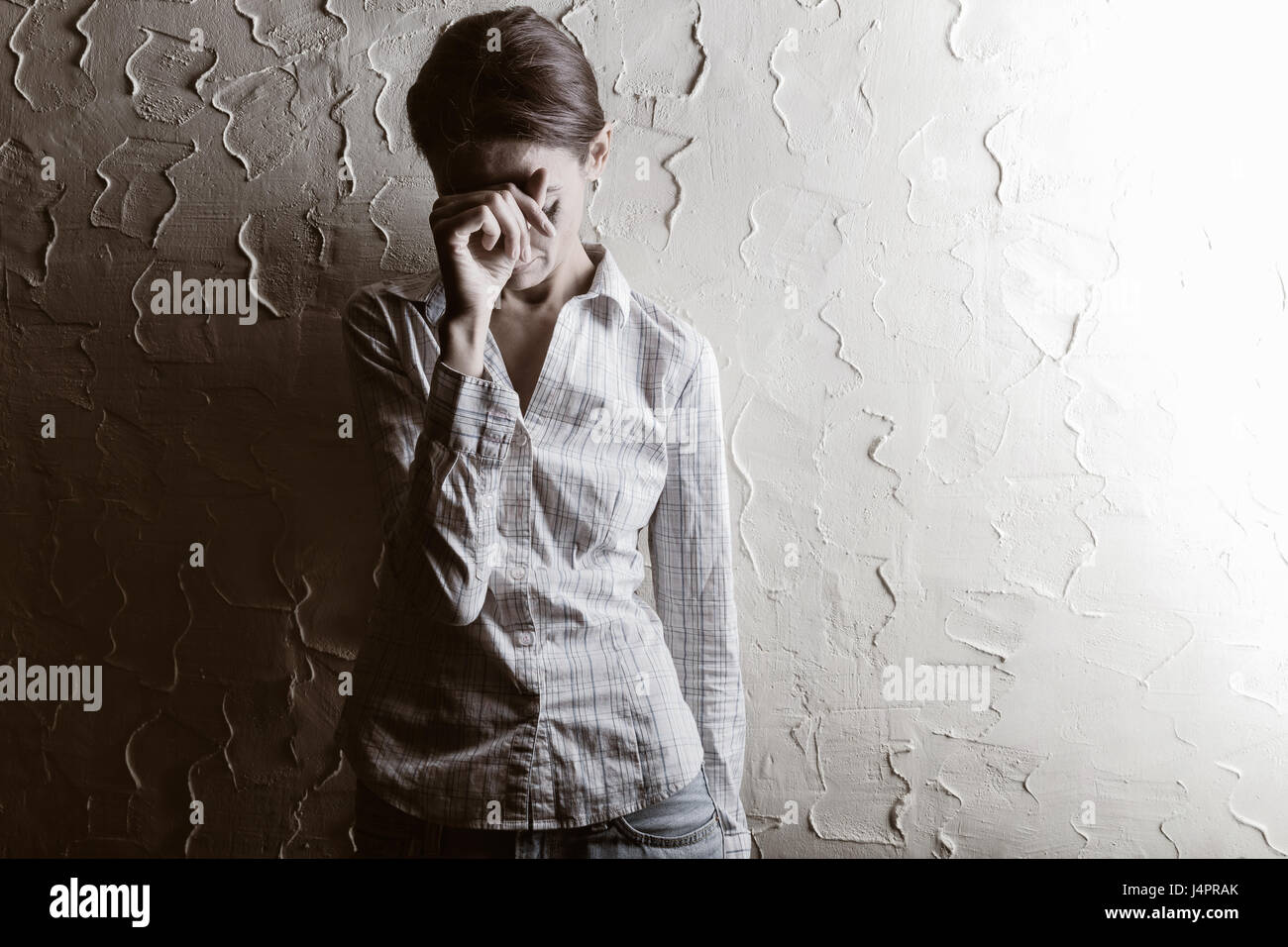 Young woman crying in wall Stock Photo - Alamy