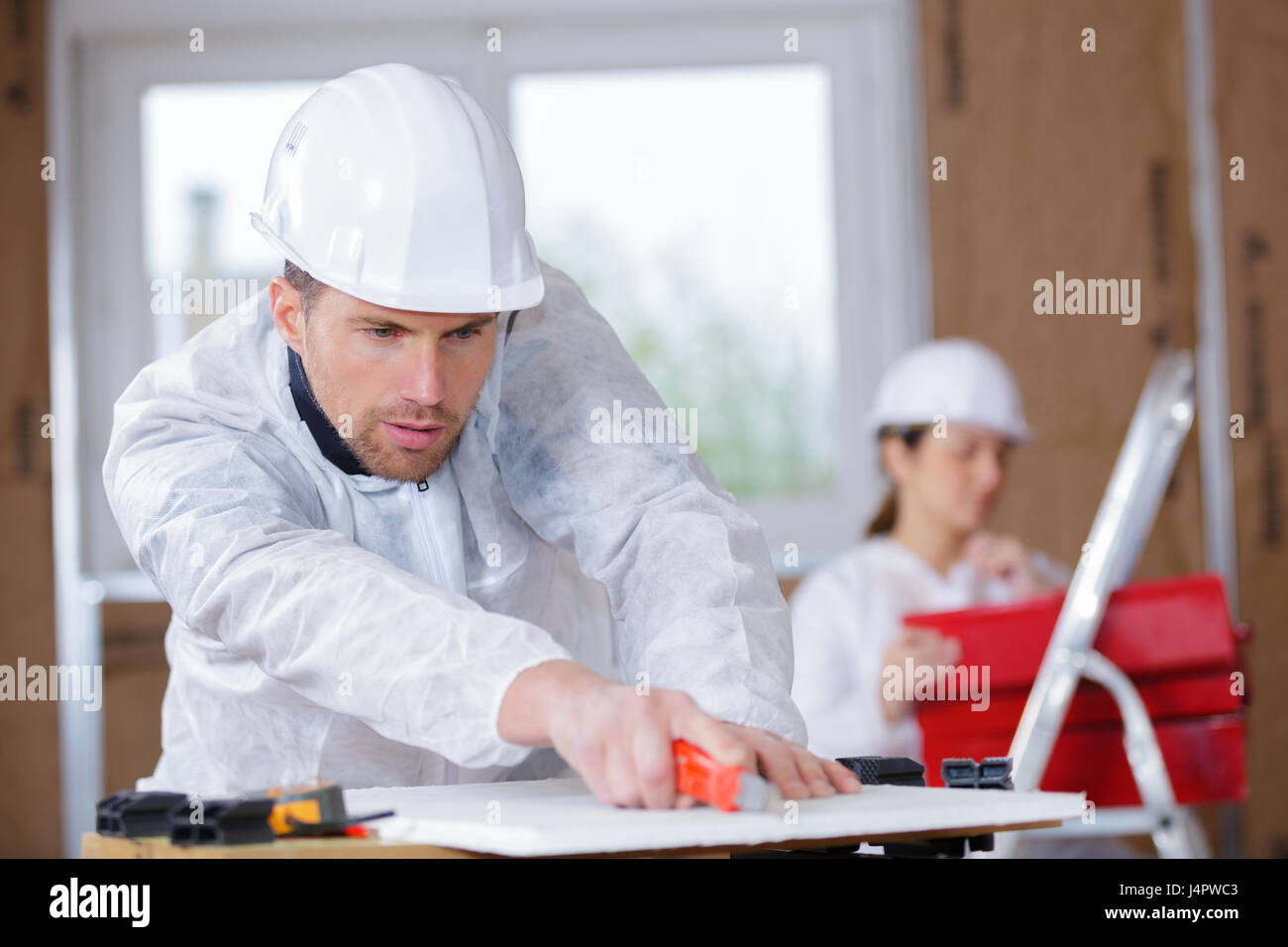 Tradesman using craft knife Stock Photo - Alamy