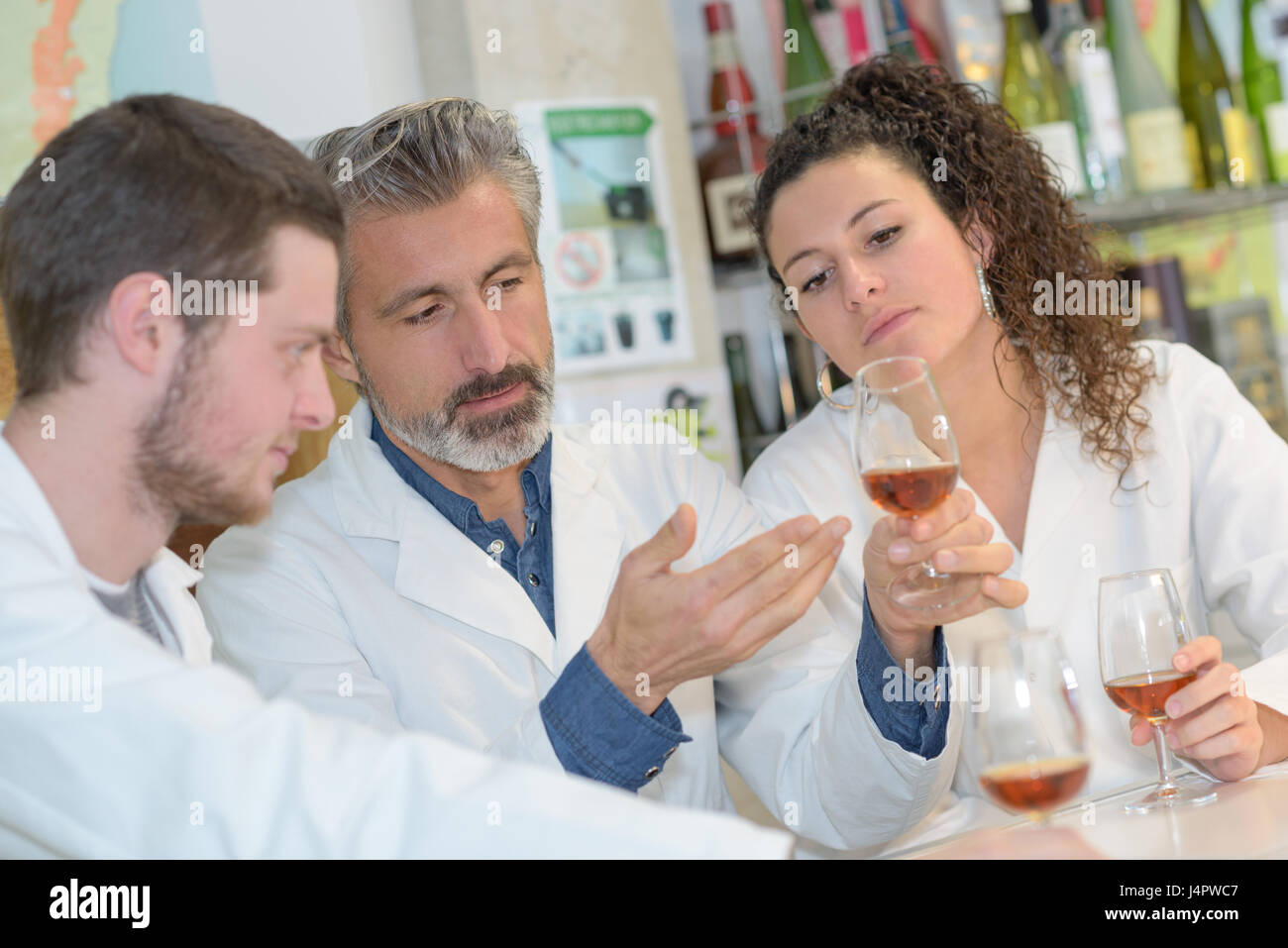 Teacher examining glass of cognac with students Stock Photo - Alamy