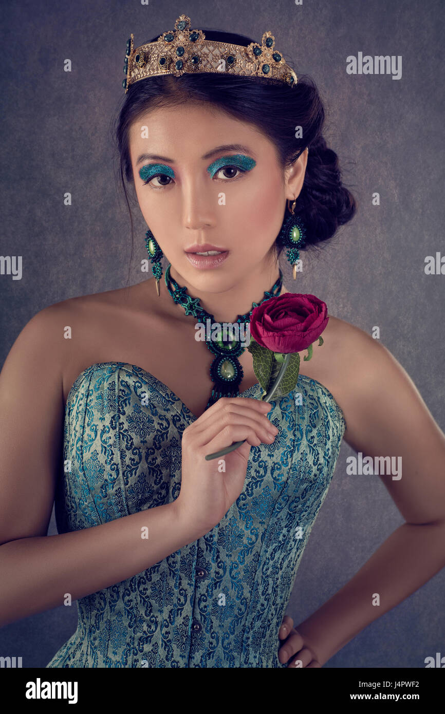 Beautiful woman with rose wearing crown Stock Photo - Alamy