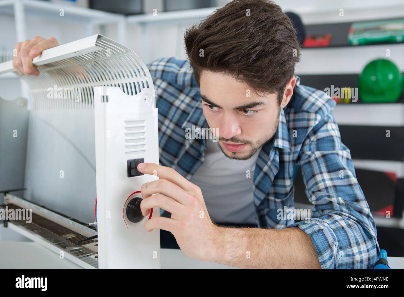 handsome young technician repairing radiator Stock Photo - Alamy