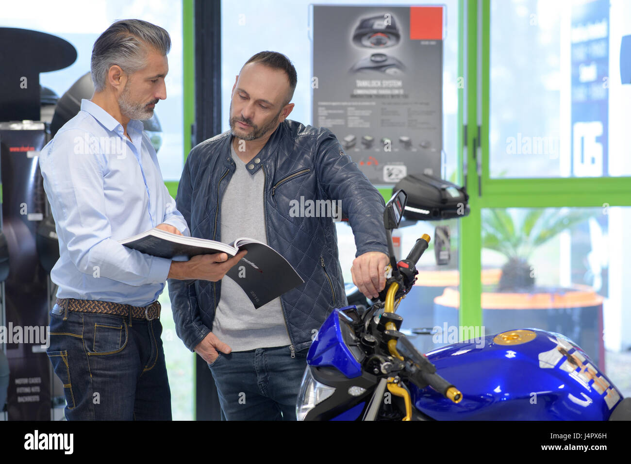 Salesman informing client about motorcycle Stock Photo - Alamy