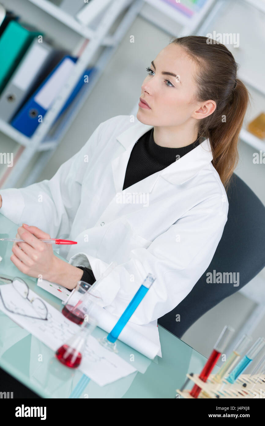 Scientist making notes at desk Stock Photo - Alamy