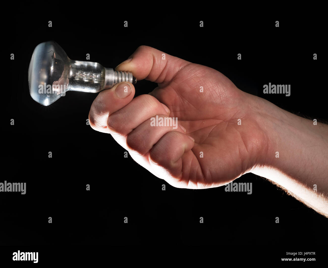 Man's hand holding electrical lamp on black background Stock Photo - Alamy