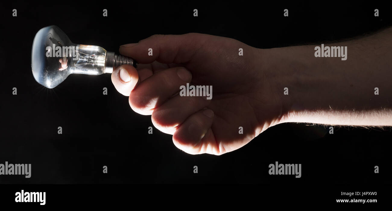 Man's hand holding electrical lamp on black background Stock Photo - Alamy