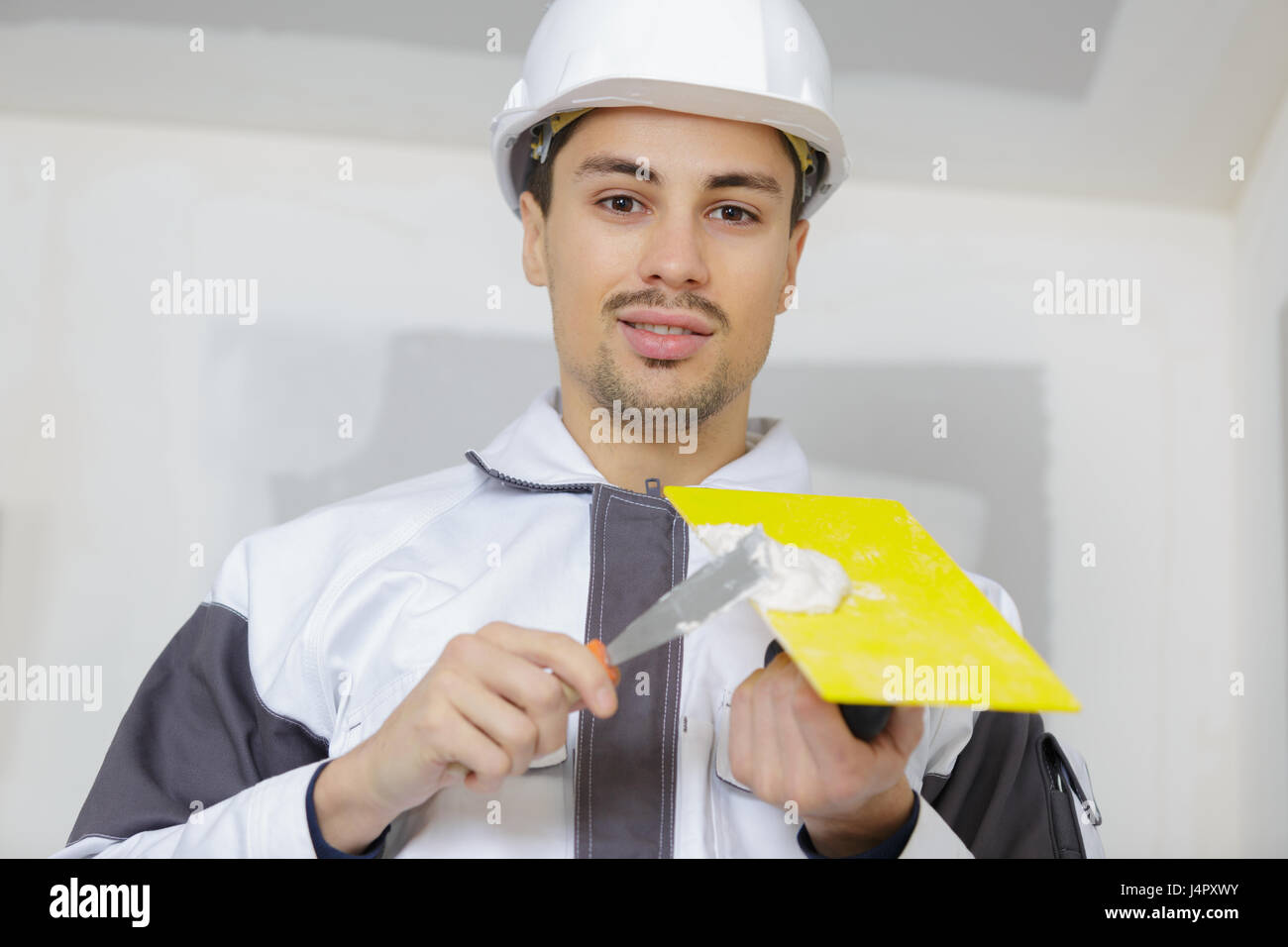 young plasterer concrete worker at wall Stock Photo - Alamy