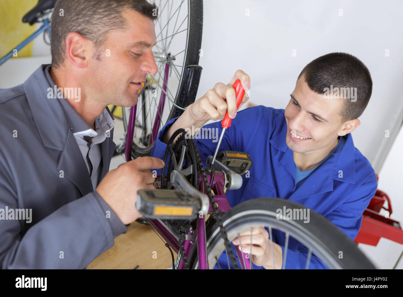 teacher and apprentice fixing a bike Stock Photo - Alamy