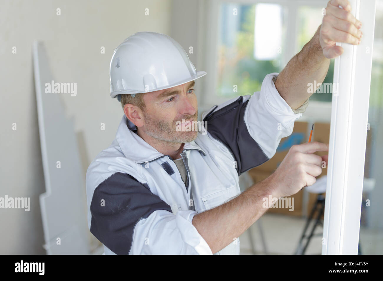 Man fitting window frame Stock Photo - Alamy