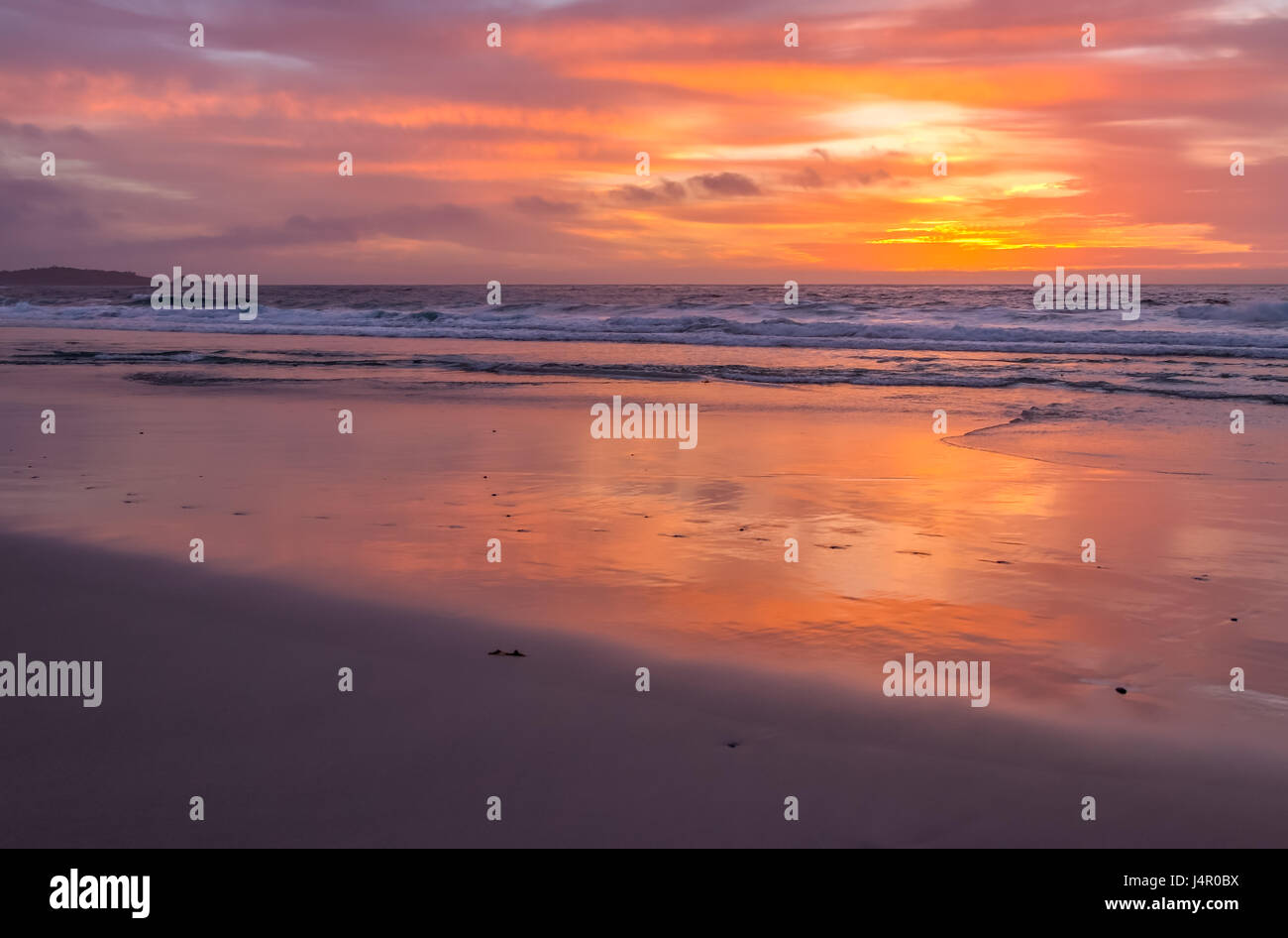 Smooth Sand Beach with Pacific Ocean Waves and Sunset in the background ...
