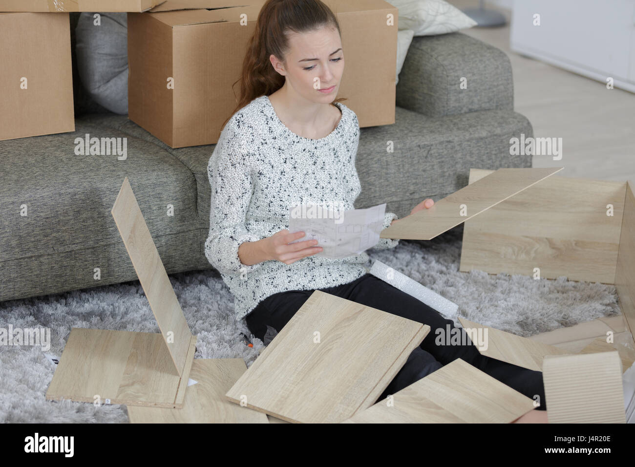 frustrated woman putting together self assembly furniture Stock Photo ...
