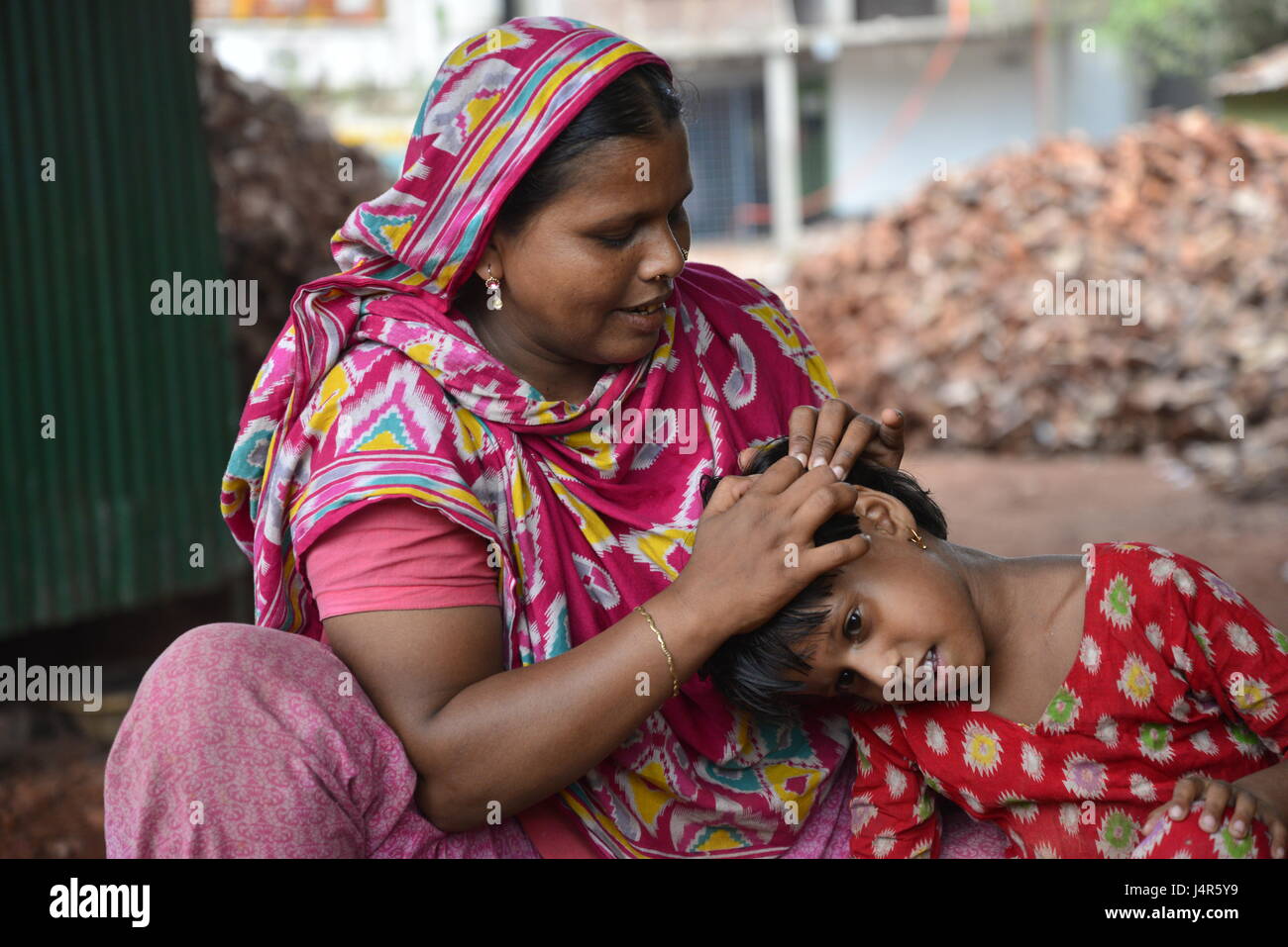 Dhaka, Bangladesh. 13th May, 2017. A worker mother and her child at her ...