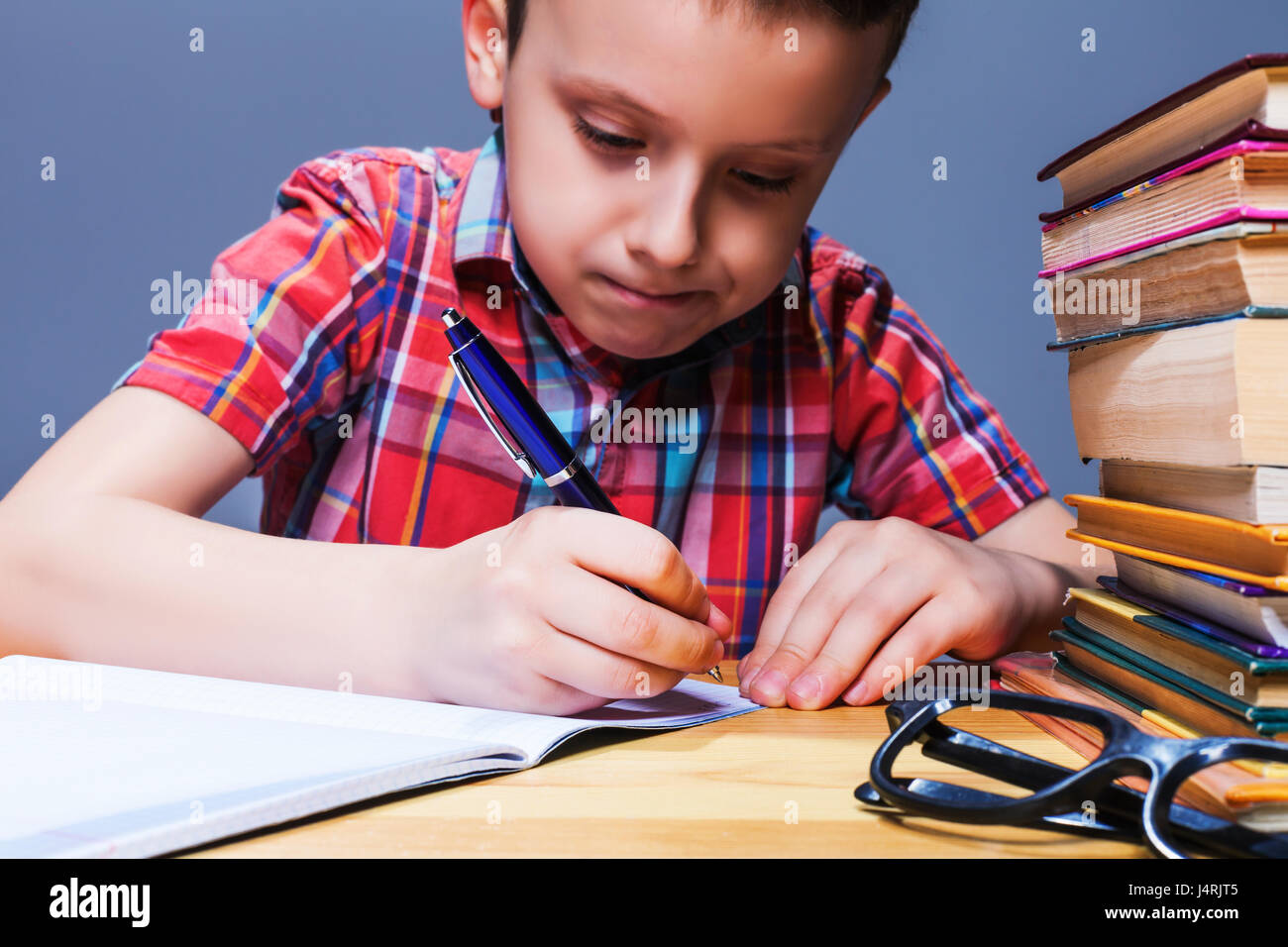 Little child writing in notebook, school homework concept. Young pupil ...