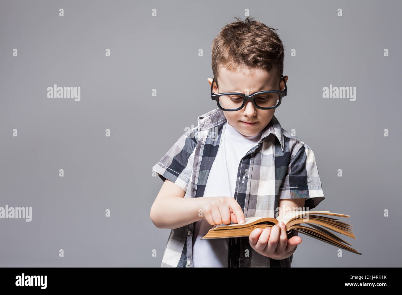 Little child with school bag and book, studio photo shoot. Young pupil ...
